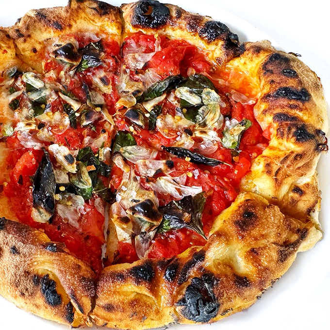 Simple yet profound: the Marinara pizza showcases that sometimes the absence of cheese creates space for tomato brilliance to shine.