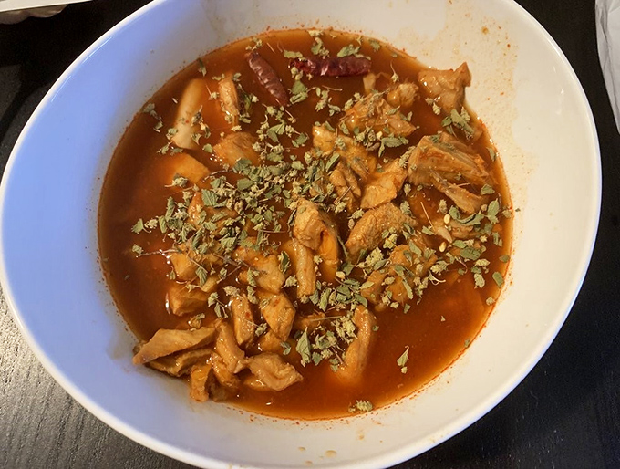 This menudo isn't just soup; it's a spicy, soul-warming ritual in a bowl, where tender meat and aromatic herbs transform humble ingredients into liquid comfort.