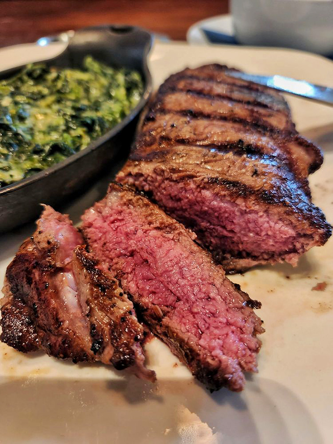 The NY strip reveals its blushing interior, a carnivore's dream with that perfect char outside and rosy tenderness within.