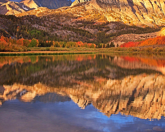 North Lake's autumn colors paint the Sierra canvas with gold and crimson, reflecting in waters so clear you can count the pebbles below.