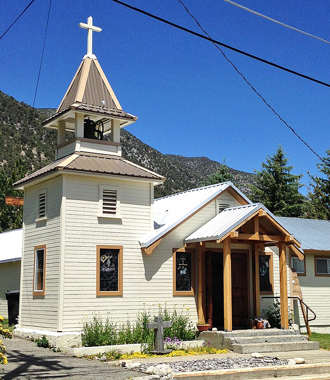 The little white church with red trim stands as a spiritual sentinel against the Sierra backdrop, where Sunday services come with heavenly views.