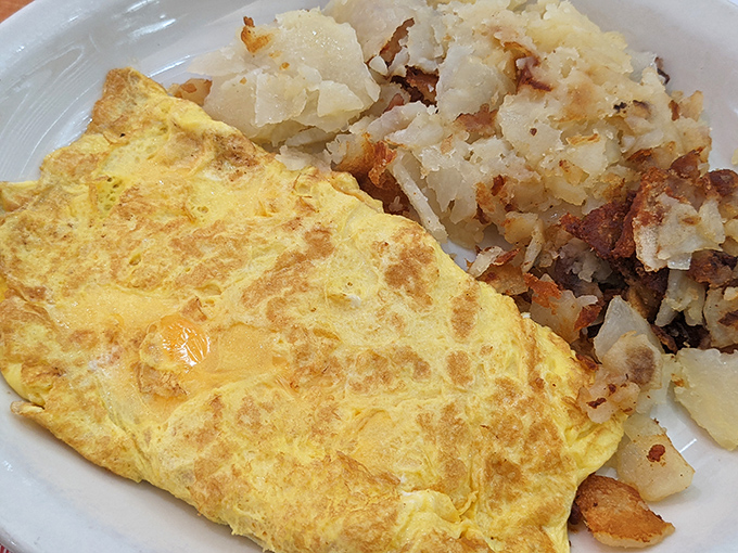 A perfect omelet that's somehow both cloud-like and substantial, paired with home fries that deserve their own fan club.