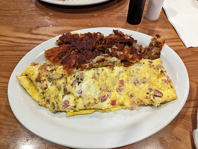 This ham and cheese omelet isn't just breakfast, it's an edible work of art paired with hash browns crisped to golden perfection.