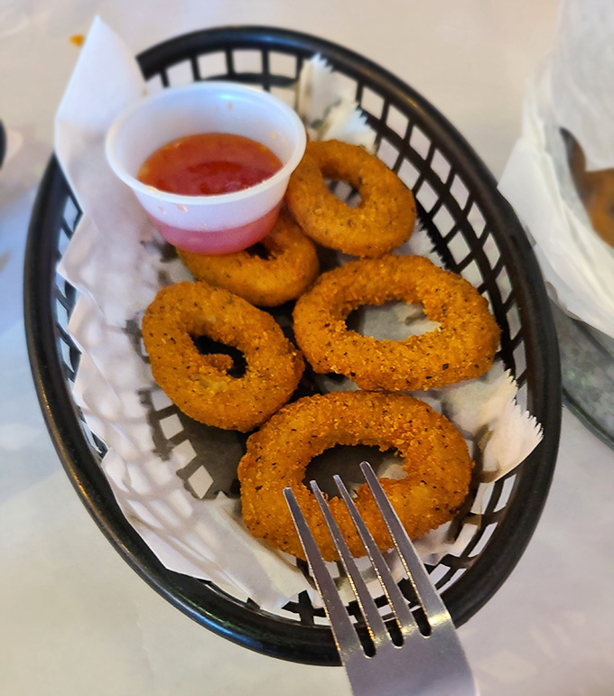 These aren't just onion rings – they're golden halos of happiness, perfectly fried and waiting to be dunked in that tangy sauce.