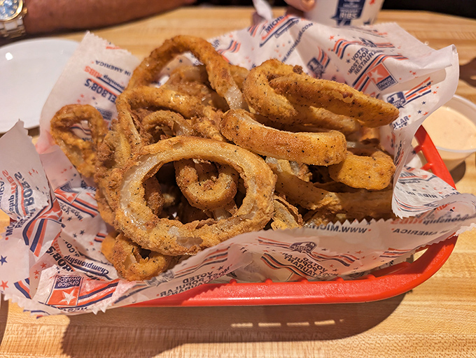 Golden onion rings arrive in a glorious tangle, each one crispier than your favorite Johnny Carson one-liner.