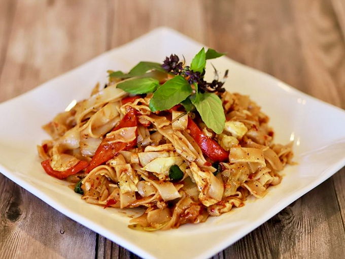 Wide rice noodles stir-fried to perfection in the Pad Kee Mao, where basil and bell peppers create a harmony that's both comforting and exciting.