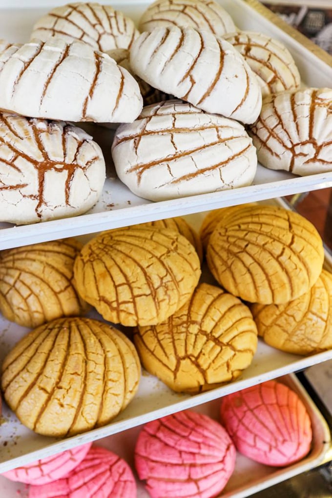 Sweet, crackle-topped conchas in white, yellow, and pink &ndash; the Mexican bakery equivalent of choosing your fighter. Spoiler alert: they're all winners.