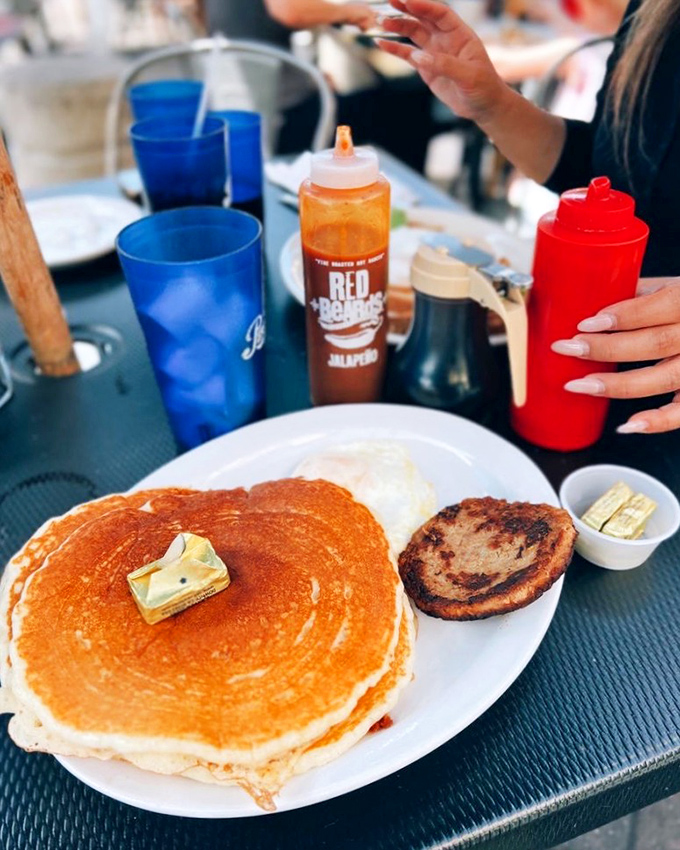 The pancake that launched a thousand Instagram posts. Golden, plate-sized, and topped with a butter pat melting into breakfast perfection.