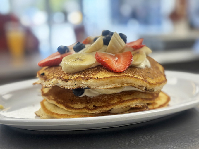 Pancakes stacked higher than your morning expectations, crowned with fresh fruit that makes you feel virtuous about eating dessert for breakfast.