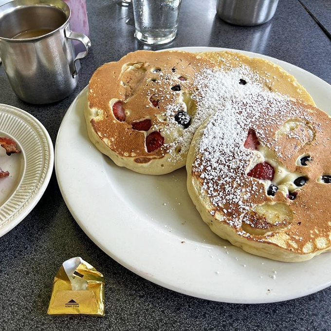 Pancakes studded with berries and dusted with powdered sugar—like little breakfast frisbees of joy that somehow improve your entire outlook on life.