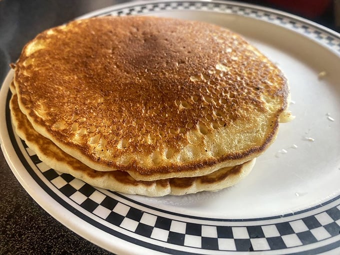 Golden pancakes stacked like edible vinyl records, playing the greatest hits of breakfast comfort since before avocado toast was born.