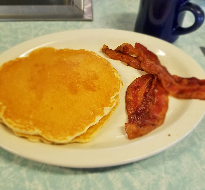Pancakes so perfectly golden they belong in Fort Knox. Paired with bacon that's achieved that magical crisp-yet-chewy texture we all chase.