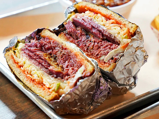 Not just a sandwich but an architectural marvel of smoked meat. This pastrami creation requires both hands, several napkins, and absolutely zero regrets.