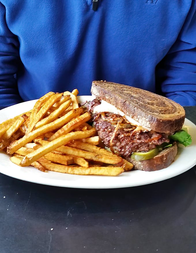 This patty melt transforms humble ingredients into pure comfort food magic, served alongside perfectly crispy fries.