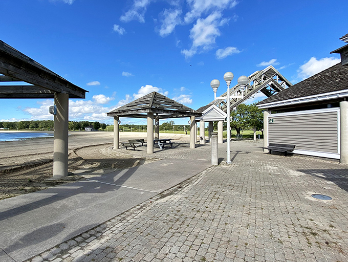 The beach pavilion stands ready for picnics, providing shade and shelter when you've had enough sun. Your sunburn will thank you later.