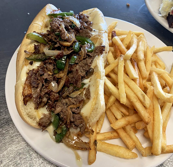 This Philly cheesesteak isn't just a sandwich&mdash;it's an architectural marvel of beef, peppers, and onions. Those fries look crispy enough to start a cult following.