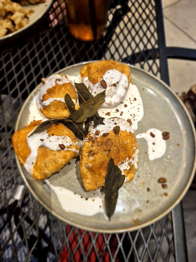 Golden-fried pierogies lounging in a pool of cream, garnished with crispy sage leaves. Comfort food that's dressed for a night out on the town.