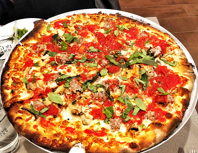 Sausage, basil, and those crushed tomatoes create a holy trinity of flavor. The char marks are like nature's signature on a masterpiece.