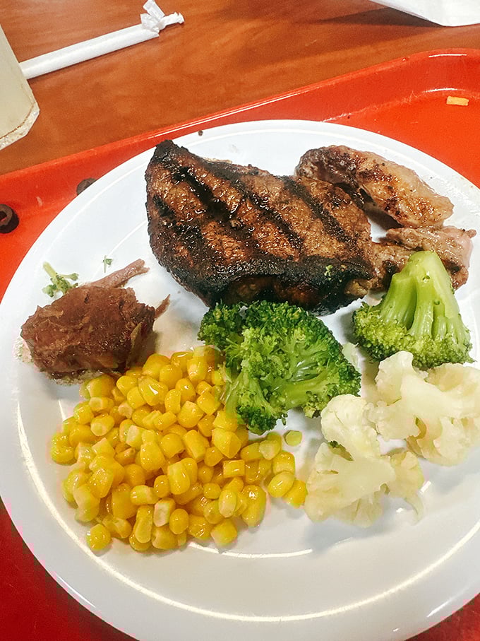 The carnivore's delight: a perfectly grilled steak sharing real estate with colorful vegetables in a peaceful plate harmony rarely seen in nature.