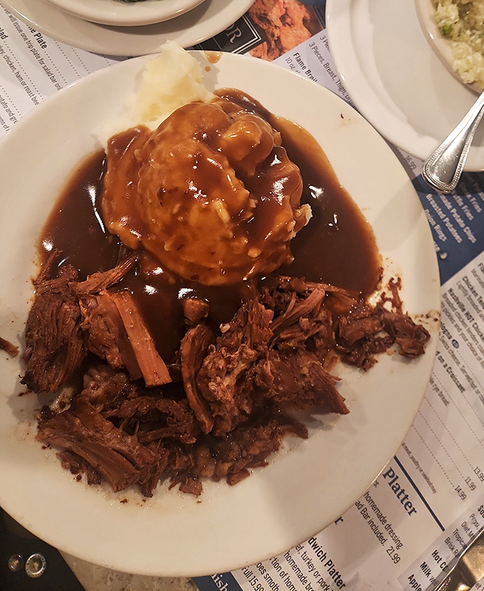 Pot roast that surrenders at the mere suggestion of your fork, swimming in gravy that should be declared a national treasure.