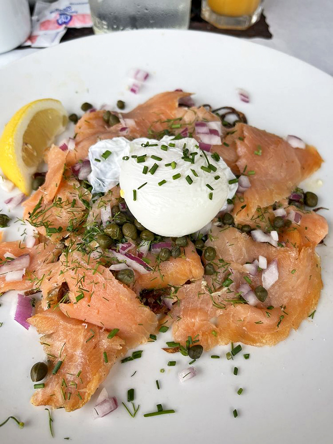 Smoked salmon arranged like a delicate flower, crowned with a perfectly poached egg&mdash;breakfast elevated to an art form.
