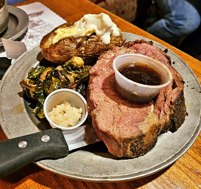 Prime rib cooked to rosy perfection, accompanied by a loaded baked potato and Brussels sprouts. Carnivore heaven that would make Fred Flintstone weep with joy.