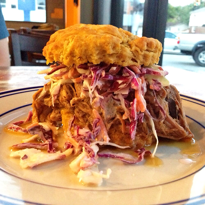 A mountain of pulled pork crowned with vibrant slaw, all nestled between sweet potato biscuit halves&mdash;proof that breakfast can be life-changing.