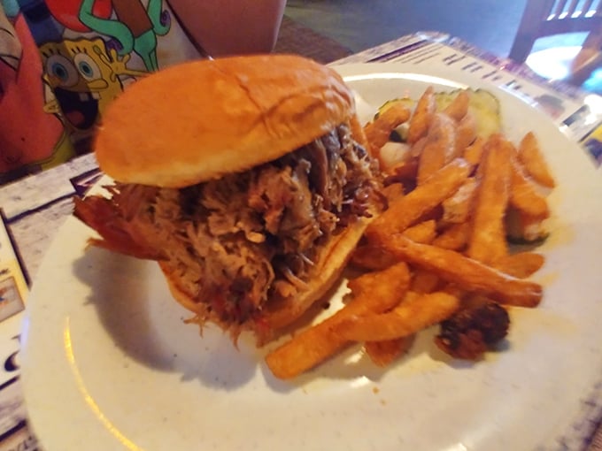 The pulled pork sandwich arrives like a mountain of smoky goodness, ready to challenge your jaw's capacity and reward your taste buds' patience.