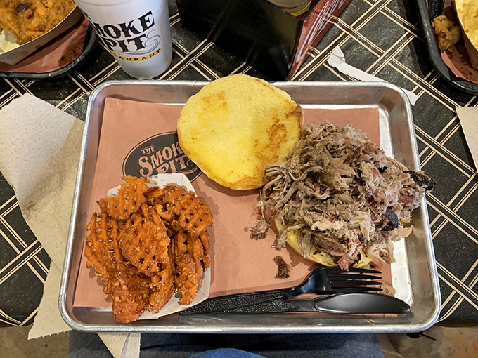 Sweet potato waffle fries, pulled pork, and cornbread – the BBQ trinity that proves heaven exists and it's served on a metal tray.