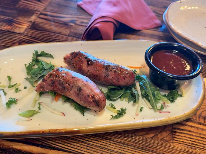 Rattlesnake sausage lounging on greens, daring you to tell your friends back home what you ate for lunch.