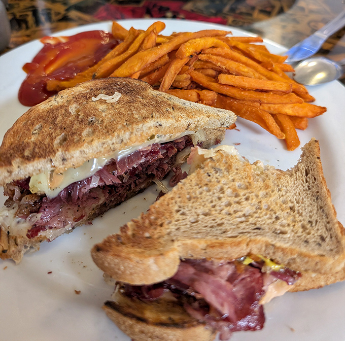 Not just a sandwich but an architectural marvel of corned beef, sauerkraut, and melted Swiss. Those sweet potato fries aren't just sidekicks&mdash;they're co-stars.