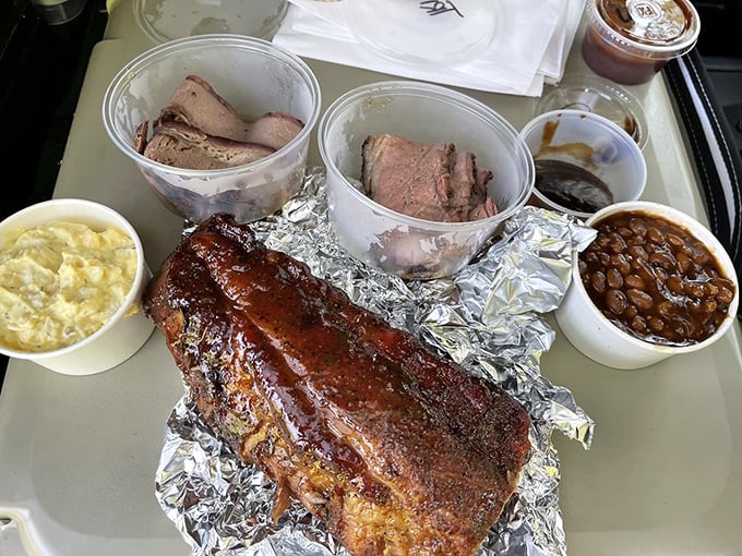 Meat paradise on a tray. The foil-wrapped ribs glisten with promise while the brisket and tri-tip wait patiently for their moment of glory.