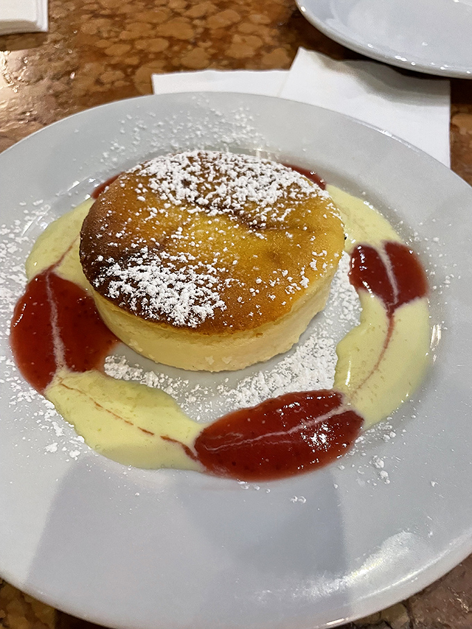 This isn't just cheesecake&mdash;it's a golden-topped ricotta masterpiece floating on custard seas with berry archipelagos. Dessert geography at its finest.