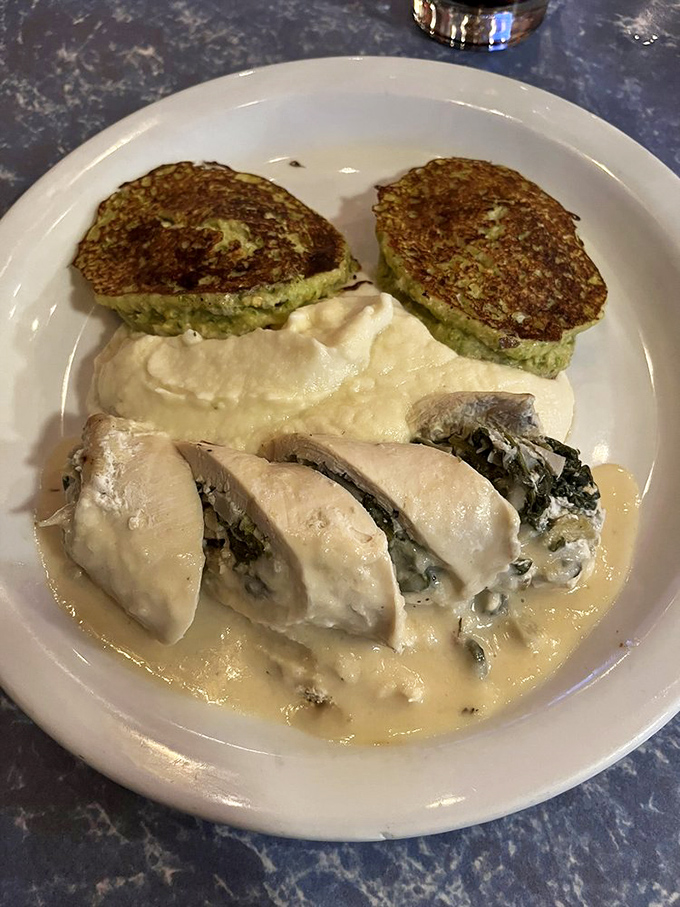 Chicken roulade that's having an identity crisis as fine dining. Those green pancakes alongside? The unexpected sidekick that steals the show.