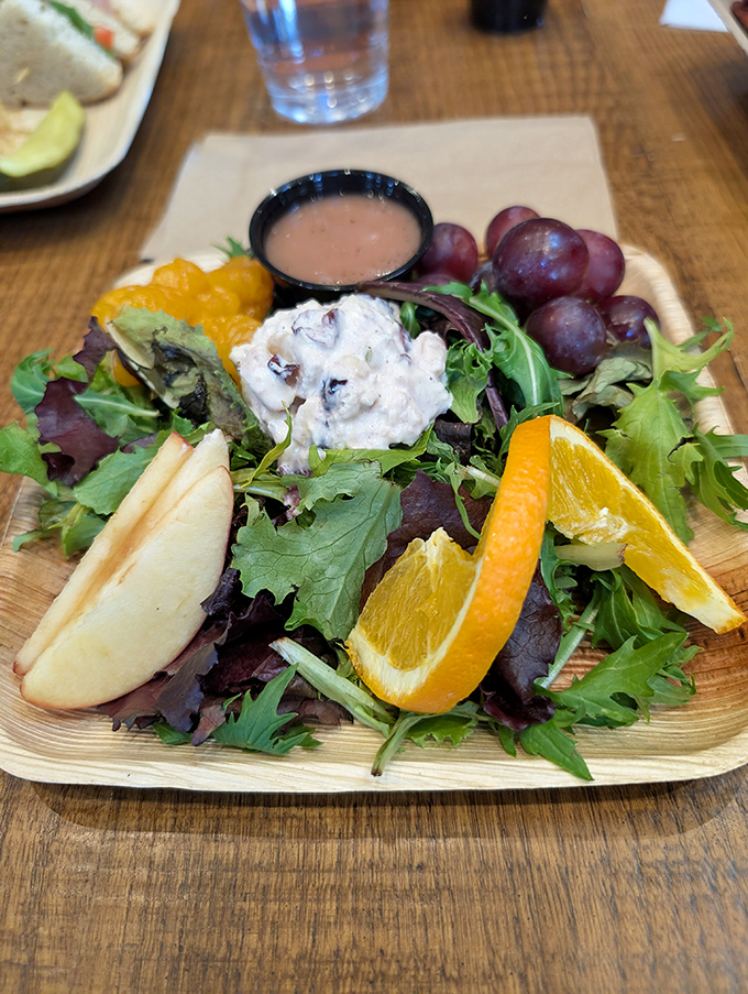 A vibrant salad that makes eating greens feel like a reward rather than a punishment—complete with fresh fruit and house-made dressing.