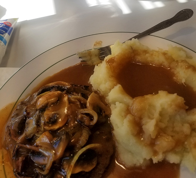 Salisbury steak with mushroom gravy and mashed potatoes&mdash;the kind of plate that makes you want to call your cardiologist just to brag about it.