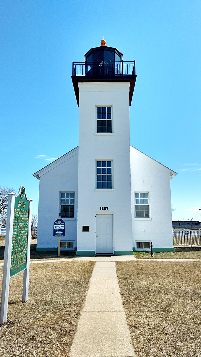 The Sand Point Lighthouse has guided mariners since 1867, standing sentinel with the quiet dignity of someone who's seen it all but tells few tales.
