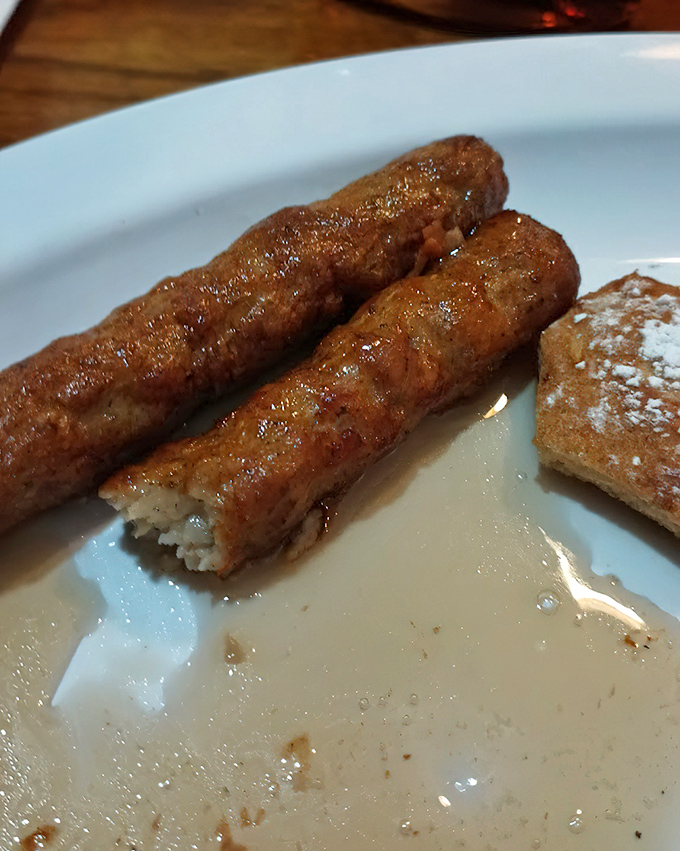 These aren't just sausage links&mdash;they're golden-brown cylinders of breakfast joy, glistening with maple syrup on a plate that screams "good morning!"