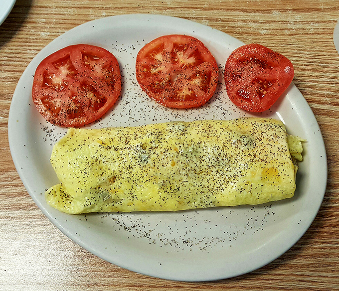 Sunshine on a plate! This omelet could make even the grumpiest morning person smile with its perfect fold and fresh ingredients.