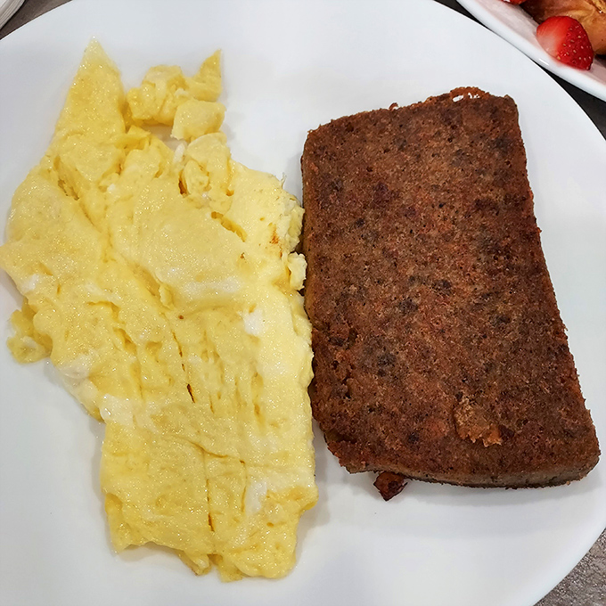 The Delaware breakfast power couple: golden scrambled eggs alongside scrapple with that perfect crispy exterior that converts skeptics into believers.
