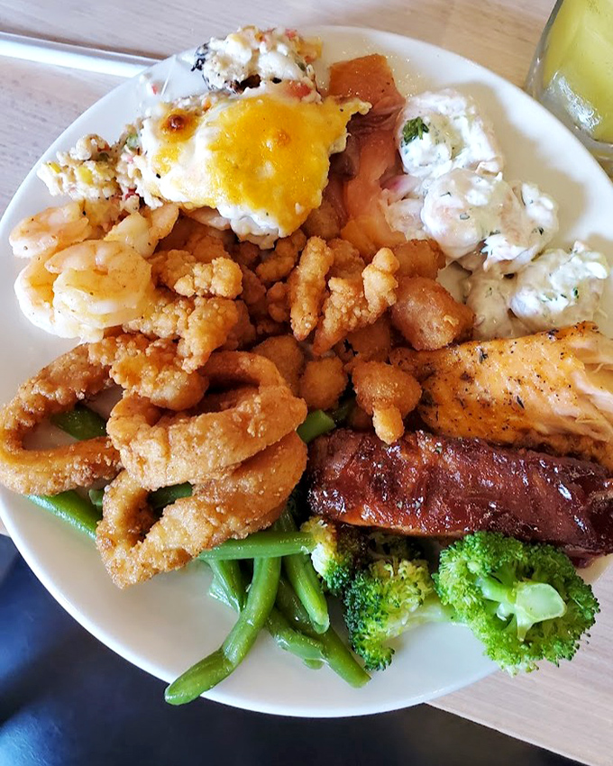 A seafood buffet plate that would make Neptune himself nod in approval&mdash;fried seafood, prime rib, and vegetables creating the perfect surf-and-turf harmony.