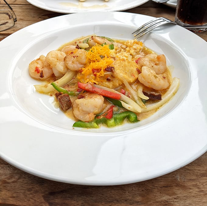 Plump shrimp lounging on creamy grits with colorful vegetables&mdash;like a seafood vacation happening right on your plate.