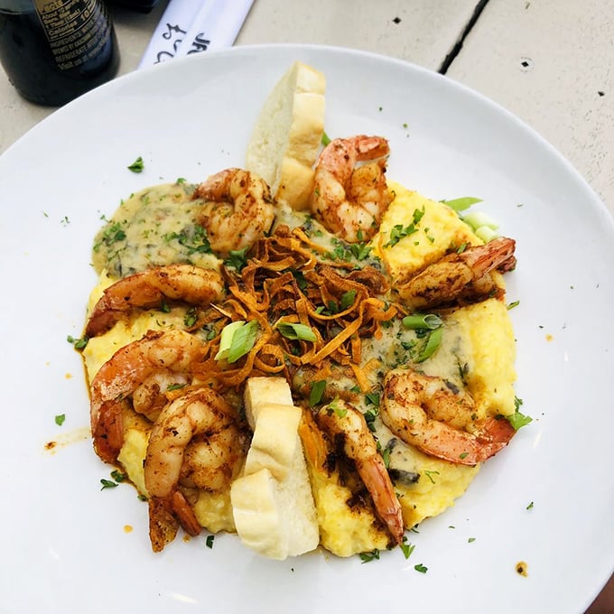 The Grits a Ya Ya in all its glory &ndash; plump Gulf shrimp nestled on a cloud of smoked Gouda grits. This isn't just dinner; it's edible Southern poetry.
