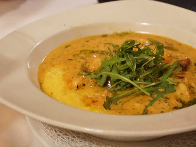 Southern comfort reimagined: creamy grits cradle perfectly cooked shrimp in a sauce that would make your grandmother both proud and jealous.