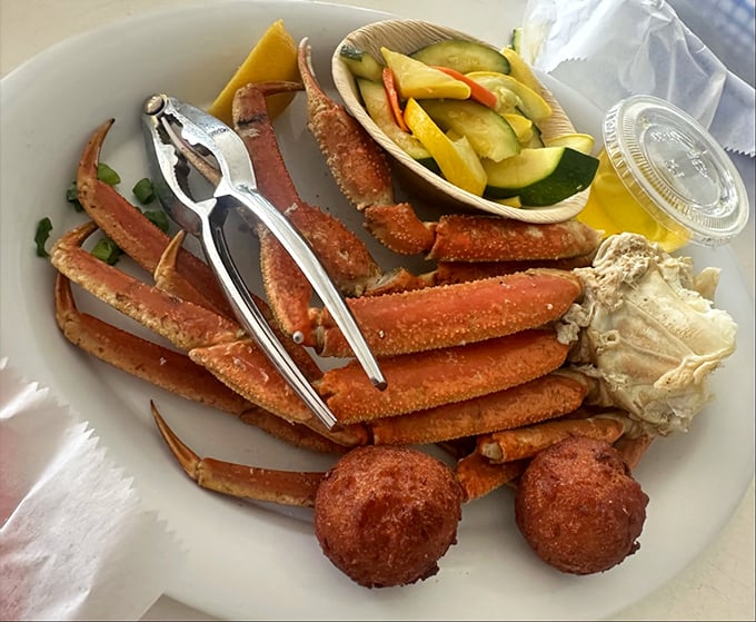 Snow crab legs arranged like nature's puzzle&mdash;where cracking the code rewards you with sweet, tender meat. Those hush puppies aren't just sidekicks.