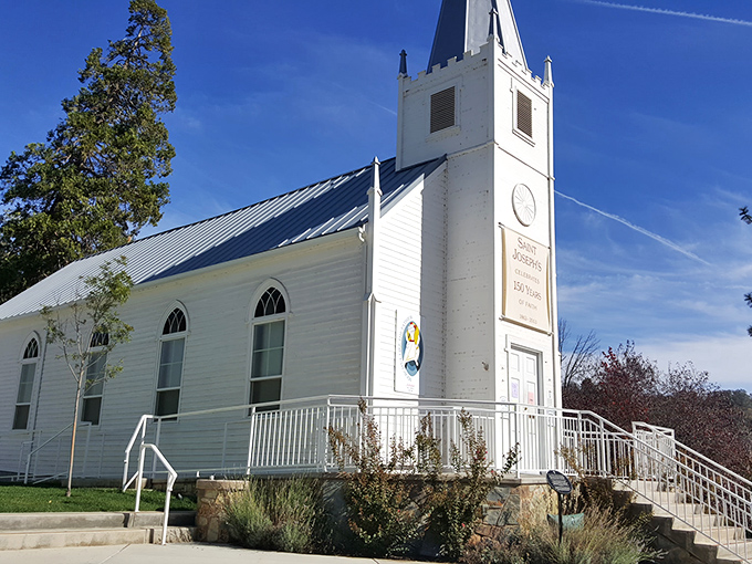St. Joseph's Church stands bright white against the blue sky. A spiritual landmark where Gold Rush prayers have echoed for generations.