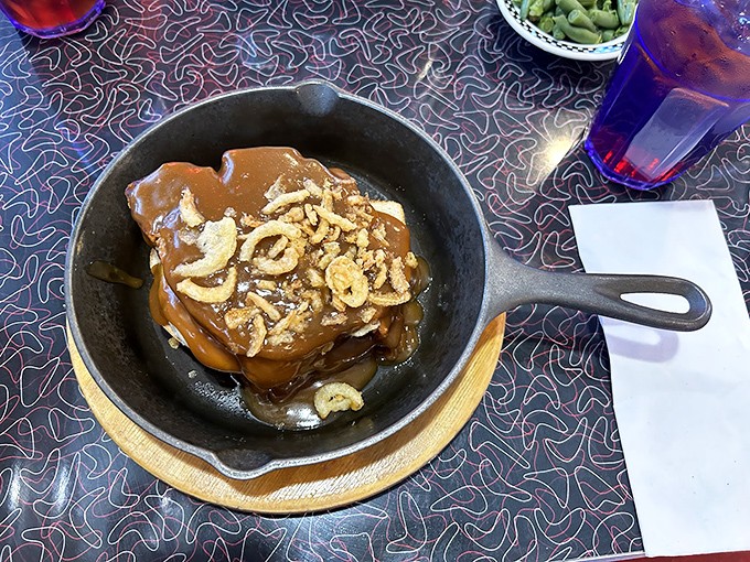 Sizzling stack meatloaf in a cast iron skillet topped with crispy onions and gravy&mdash;this isn't your Monday night leftovers, it's a Midwest masterpiece.