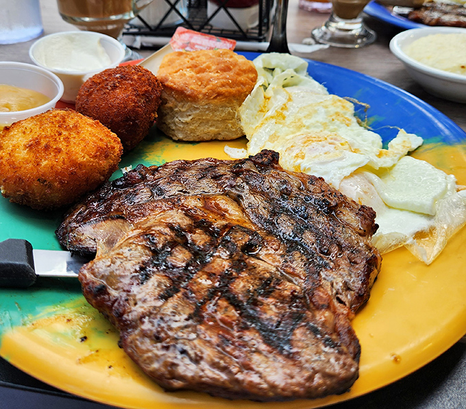 This isn't just steak and eggs; it's a carnivore's dream vacation on a colorful plate with a fluffy biscuit as your plus-one.