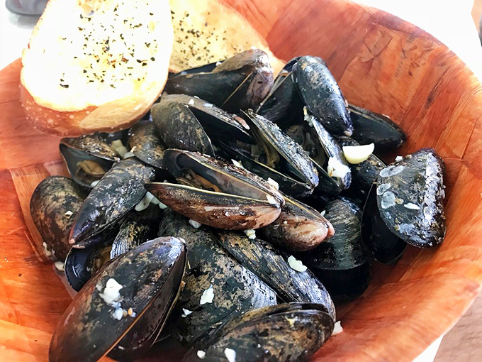 Steamed mussels nestled in their inky shells, ready to surrender their sweet meat to anyone wise enough to order them. That garlic bread isn't just a side&mdash;it's essential equipment.