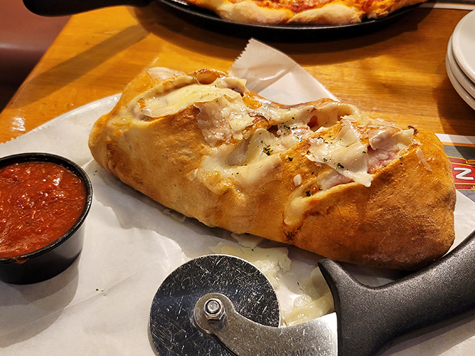 This stromboli isn't just folded dough&mdash;it's an architectural masterpiece of cheese and meat. The marinara sidekick stands ready for its supporting role.
